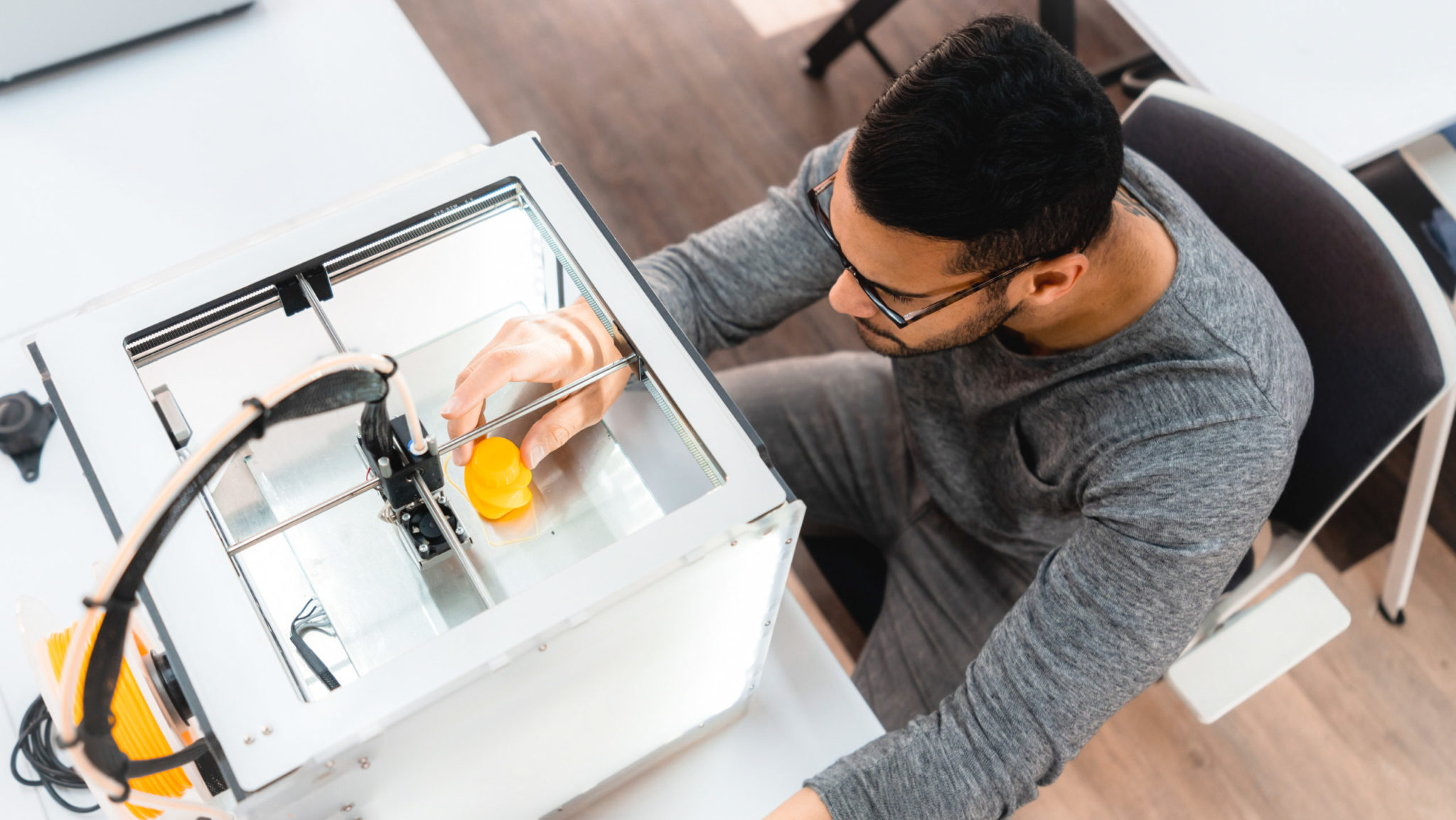 Man using a 3D printer - RoboDK blog